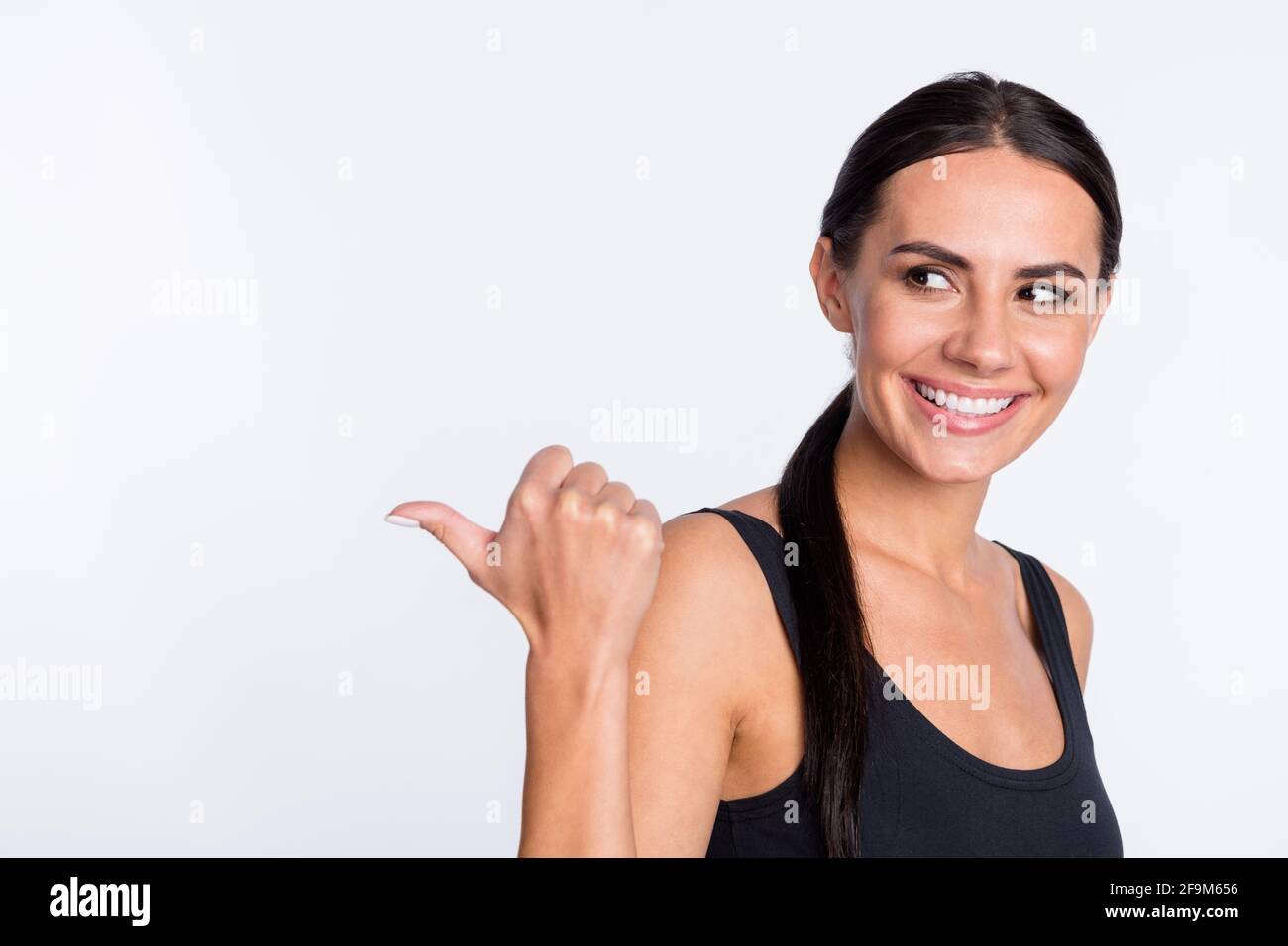 Photo of brunette ponytail haired lady point look empty space recommend ...