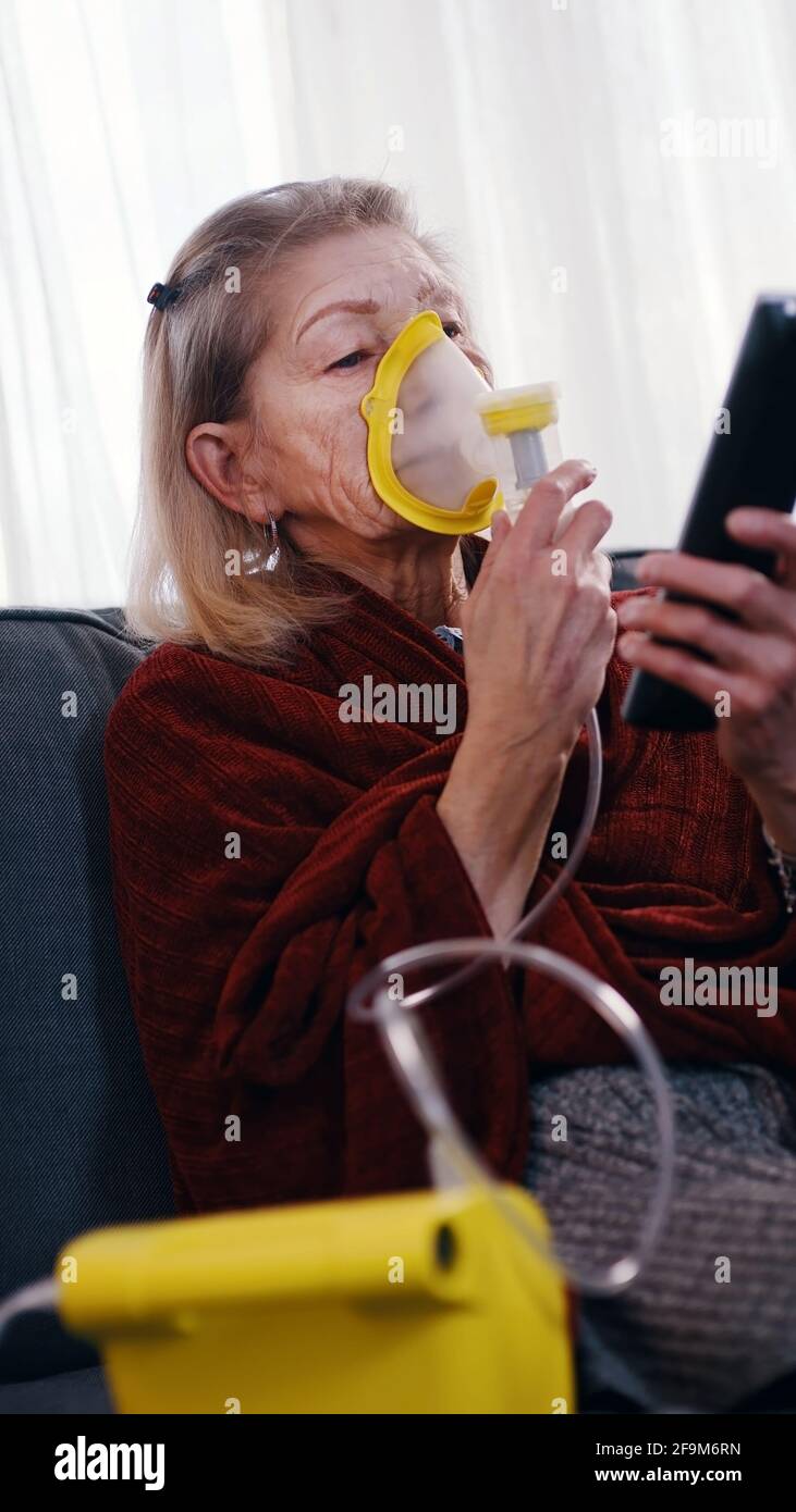 Vulnerable old woman in quarantine using oxygen inhaler and changing ...