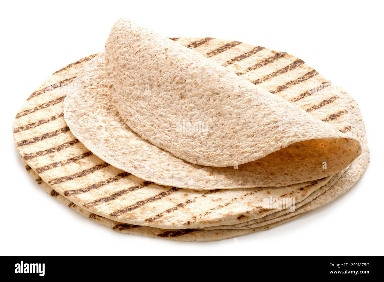 Folded spelt and oat tortilla on top of a stack of plain tortilla wraps ...