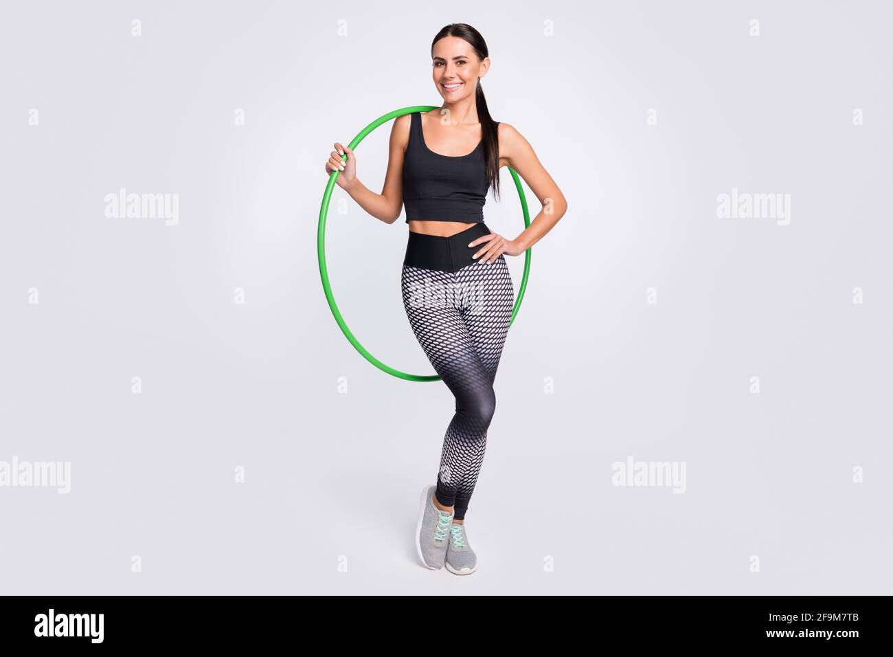 Full size photo of charming nice young woman hold hands hula hoop smile ...