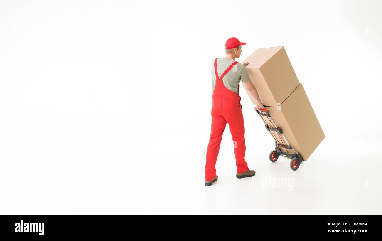 rear view of delivery man holding push cart loaded with cardboard boxes ...