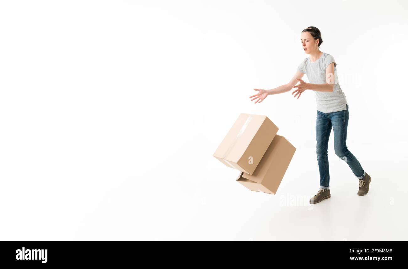clumsy young woman dropping moving boxes and tripping. on white ...