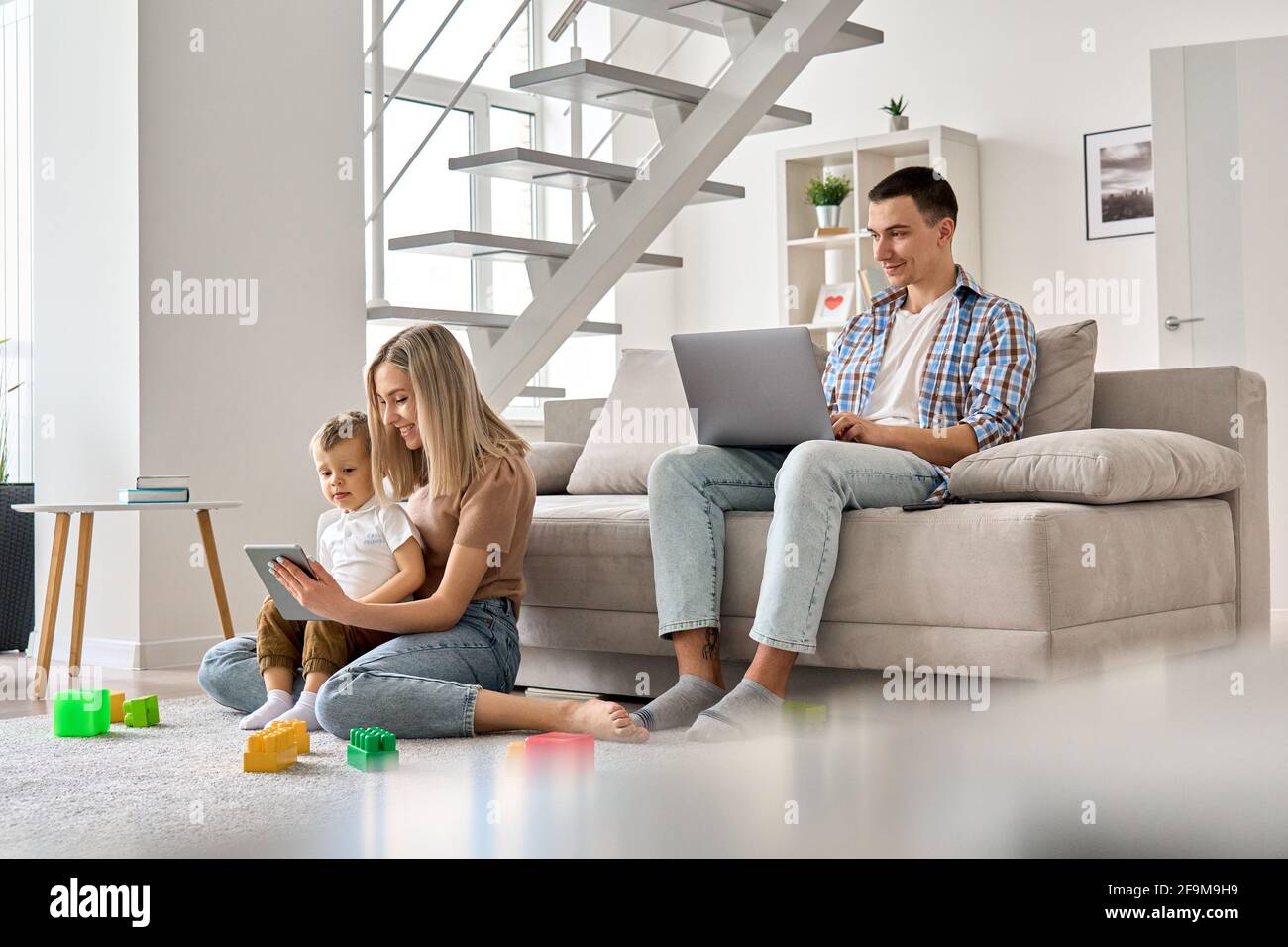 Happy family mom, dad and child son using laptop and digital tablet at ...