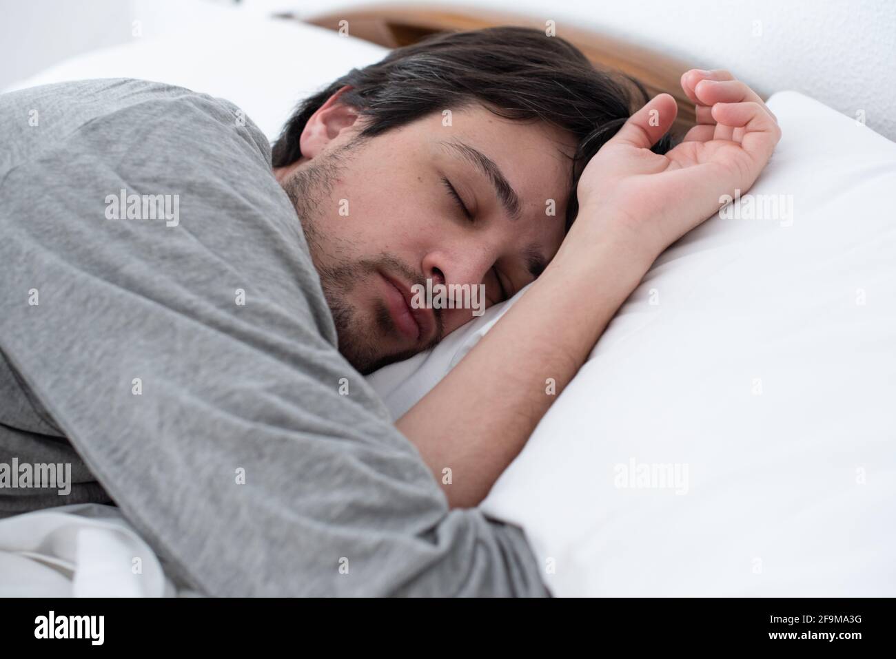 Young man sleeping peacefully lying in bed Stock Photo - Alamy