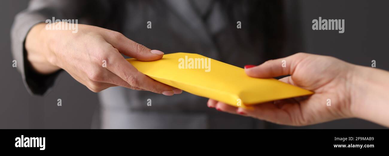 Womans hand giving envelope to another woman concept Stock Photo - Alamy