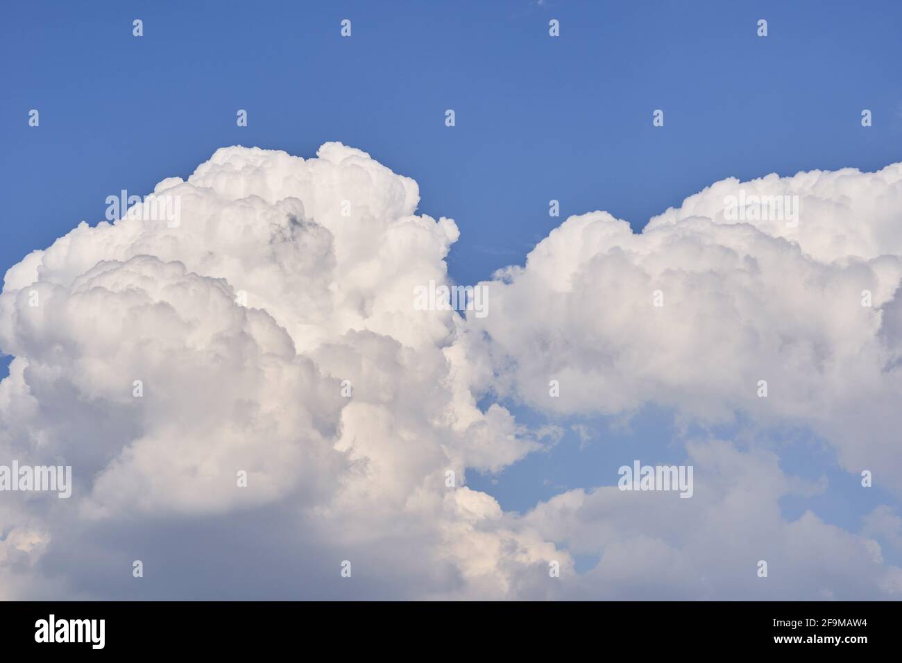 Big white fluffy cumulonimbus clouds floating on blue sky on bright ...