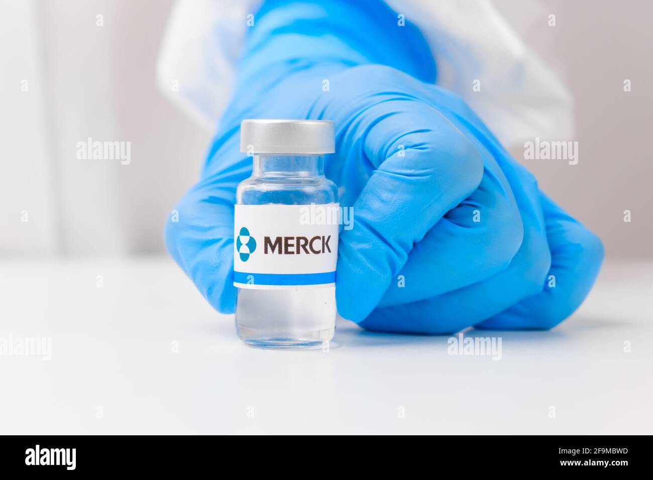 Merck vial or bottle with pharmaceuticals demonstrated by health worker ...
