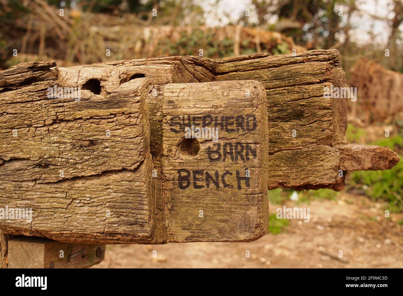 A close up of the end of an old rustic bench in a farmer's field ...