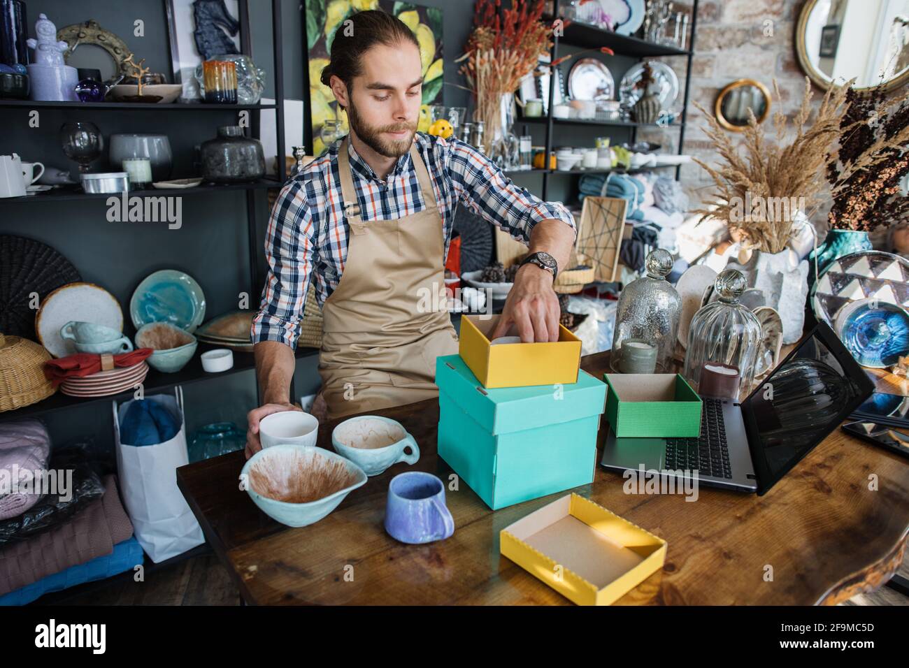 Handsome caucasian seller receiving unique goods at decor shop. Bearded ...