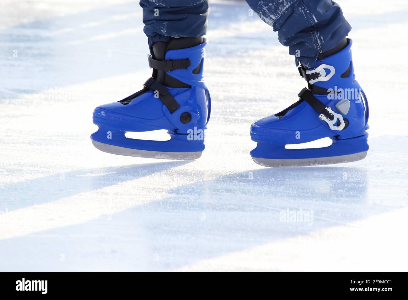 legs in blue skating on the ice rink Stock Photo - Alamy