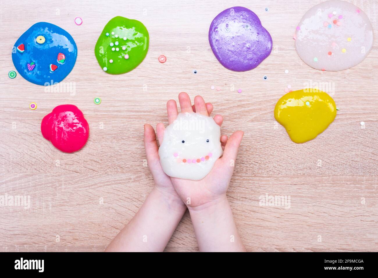 Multi-colored slimes on the table. The child plays with mucus. Slime ...