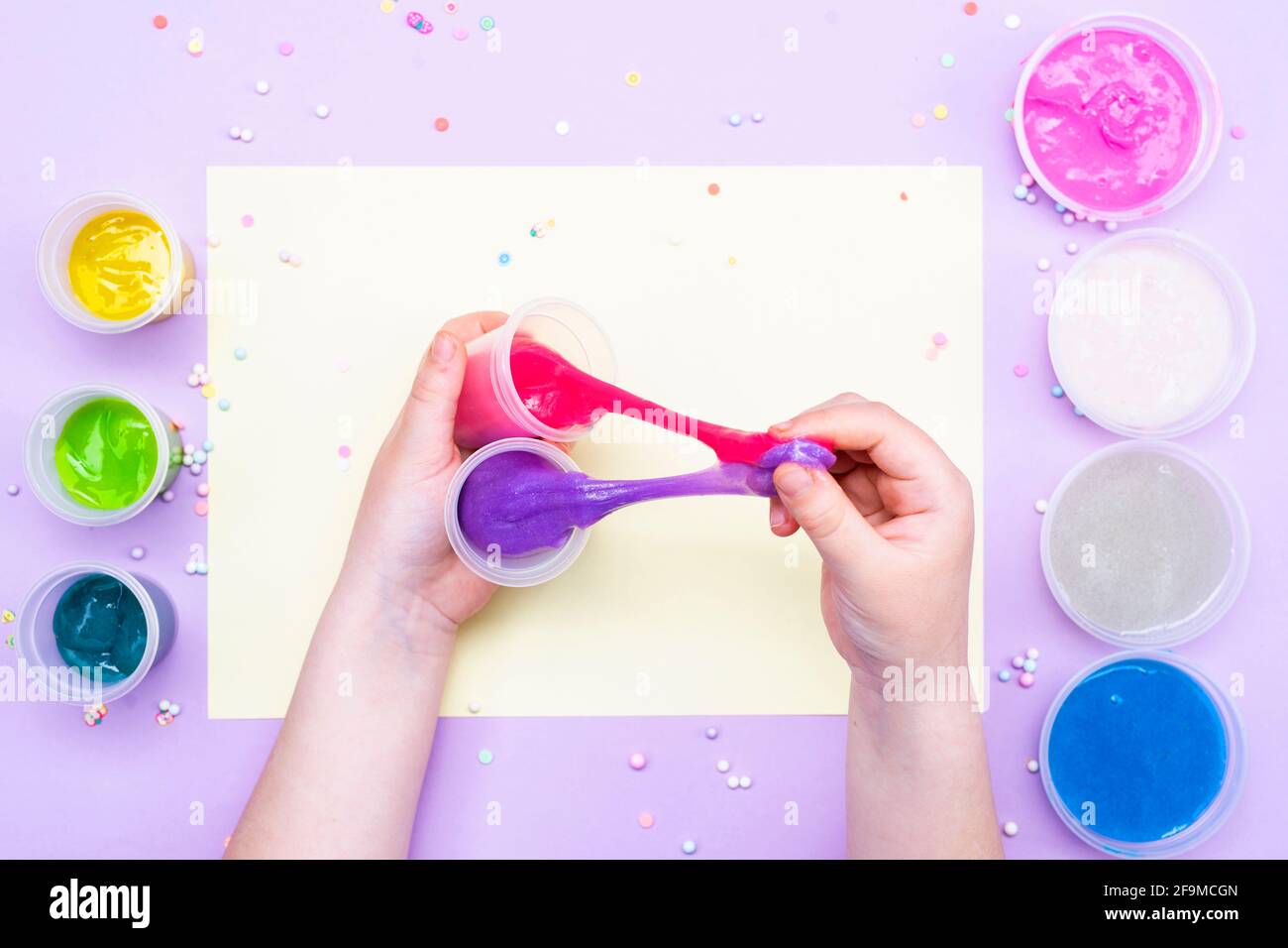Multi-colored slimes on the table. A child plays with a slime. Play toy ...