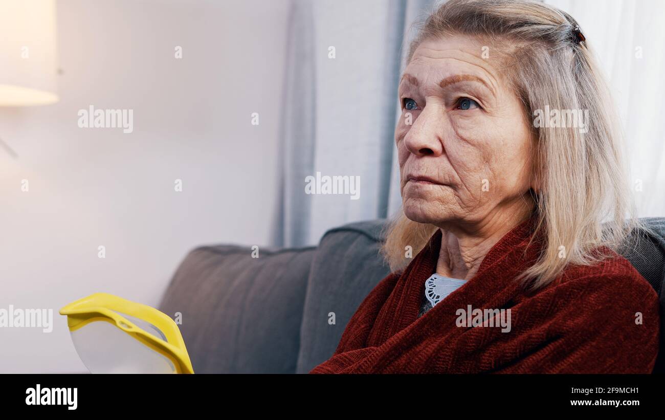 Vulnerable old woman having a phone call and using inhaler. Difficulty ...