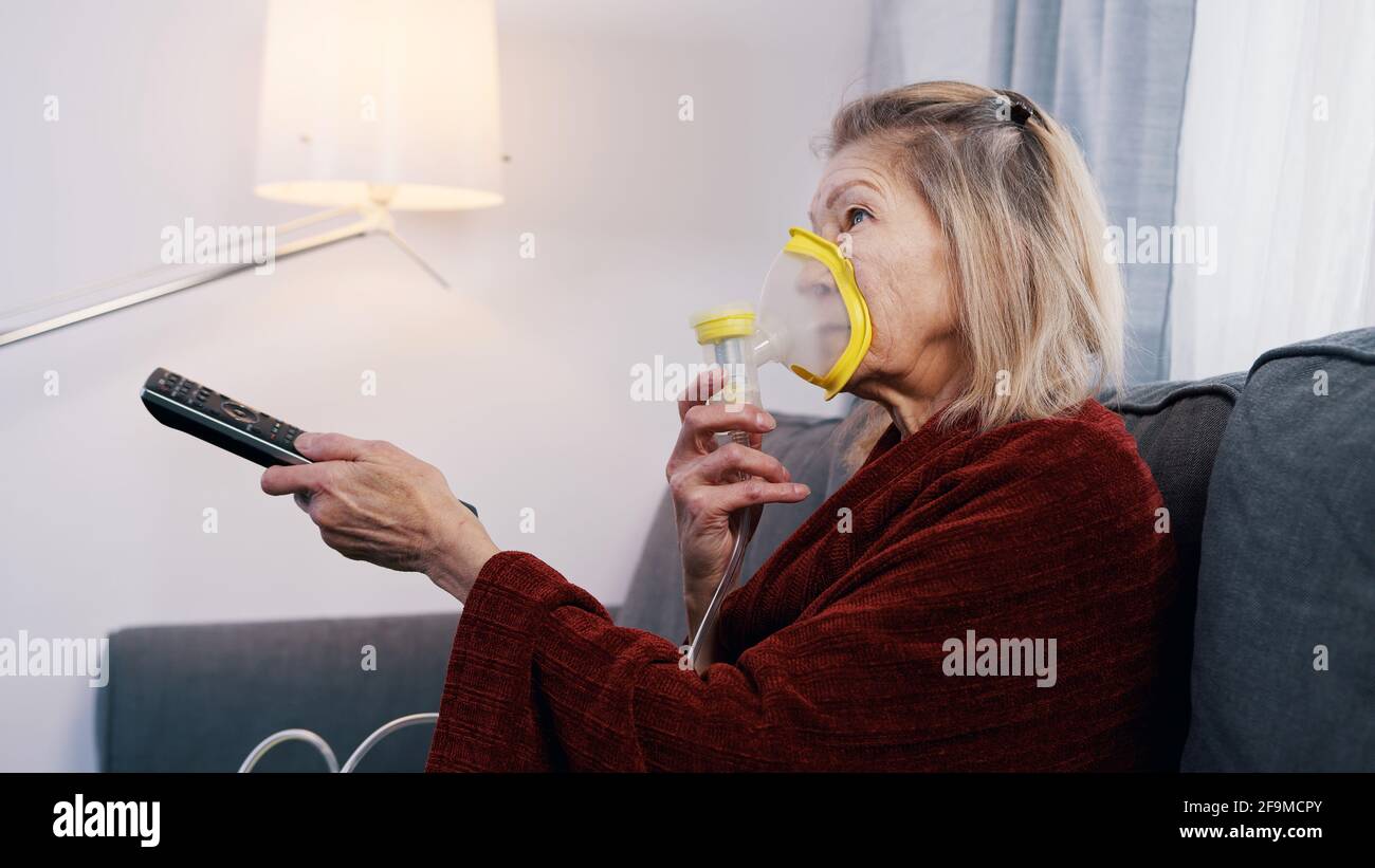 Vulnerable old woman in quarantine using oxygen inhaler and changing ...