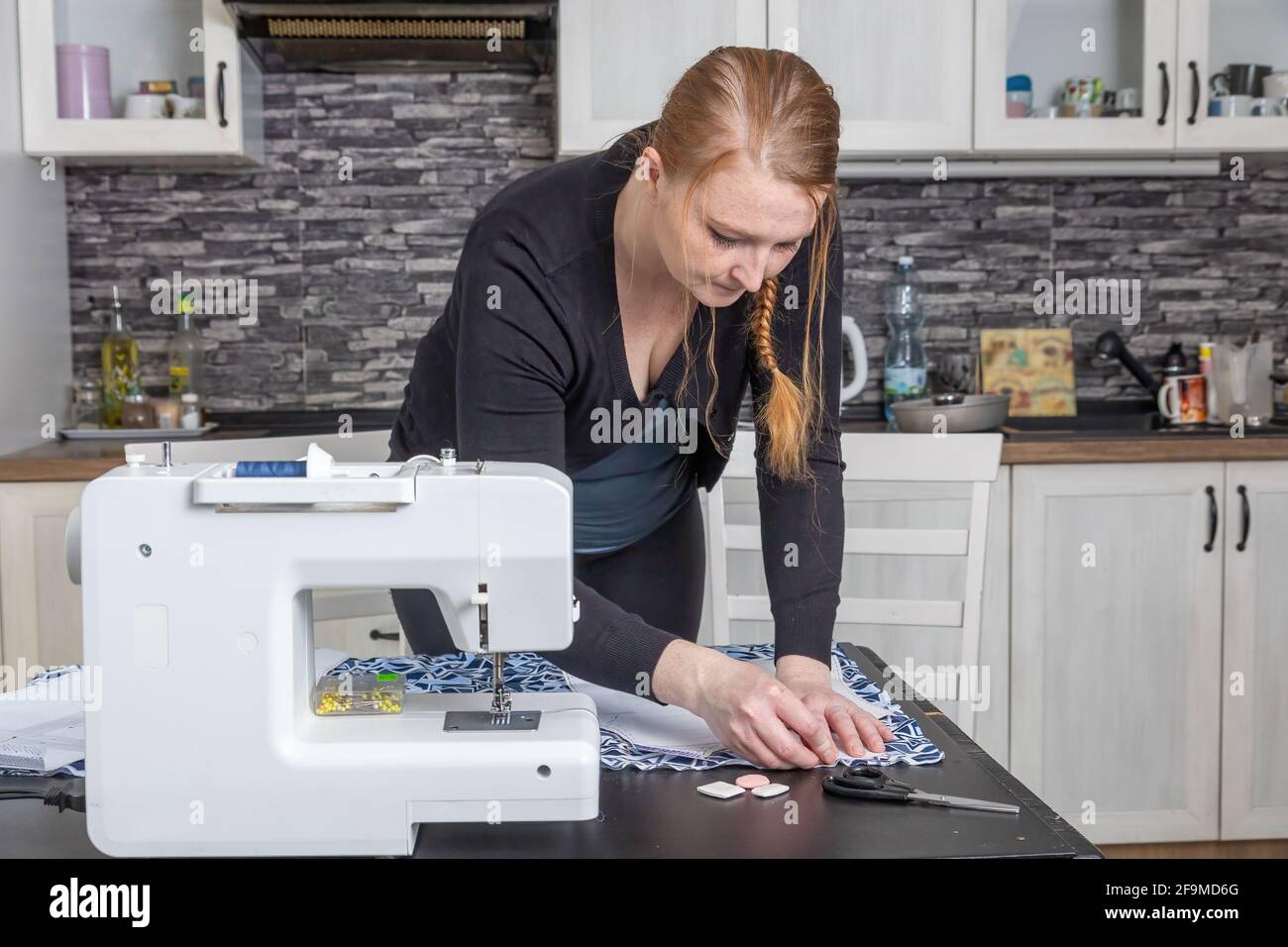 Young woman is preparing the fabric for sewing at home. Horizontally ...