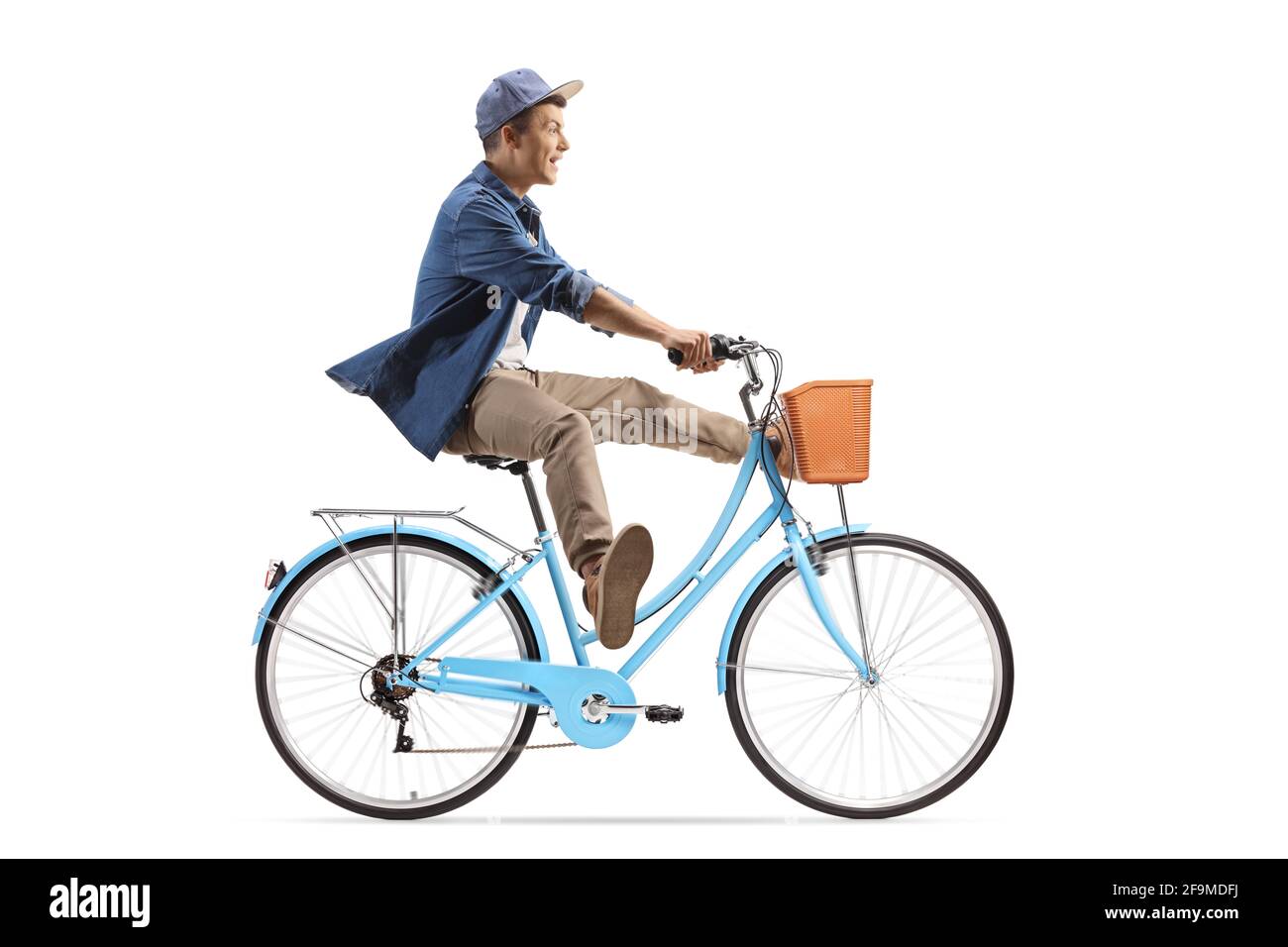 Full length profile shot of a guy riding a bicycle and lifitng legs ...