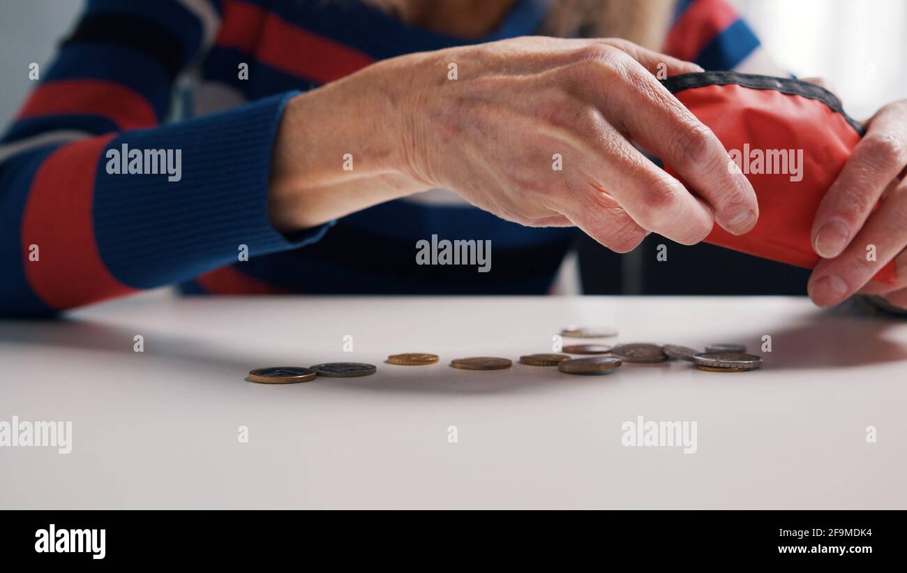 Elderly person putting money into her wallet. Poor woman running out of ...