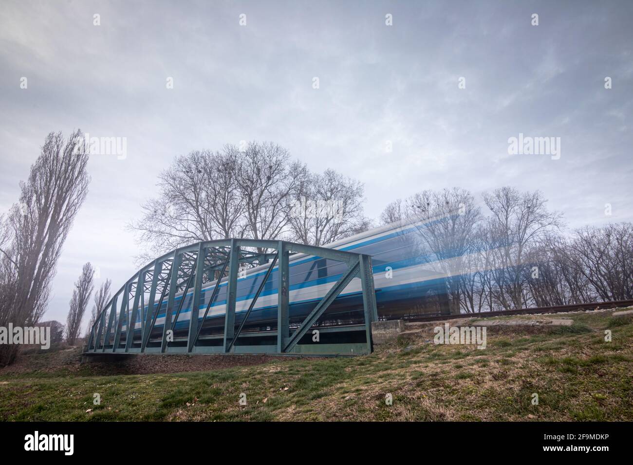 Old rusty truss bridge with moving freight train over the Orljava river ...