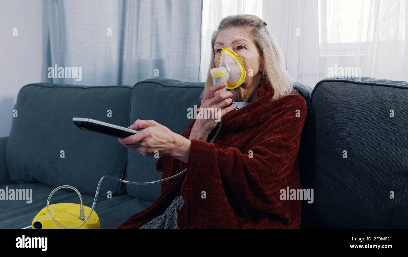 Vulnerable old woman in quarantine using oxygen inhaler and changing ...