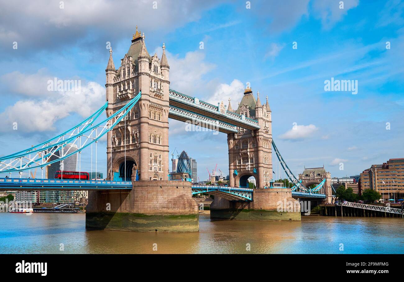 Tower Bridge on a bright sunny day with blue sky and clouds. Calm water ...