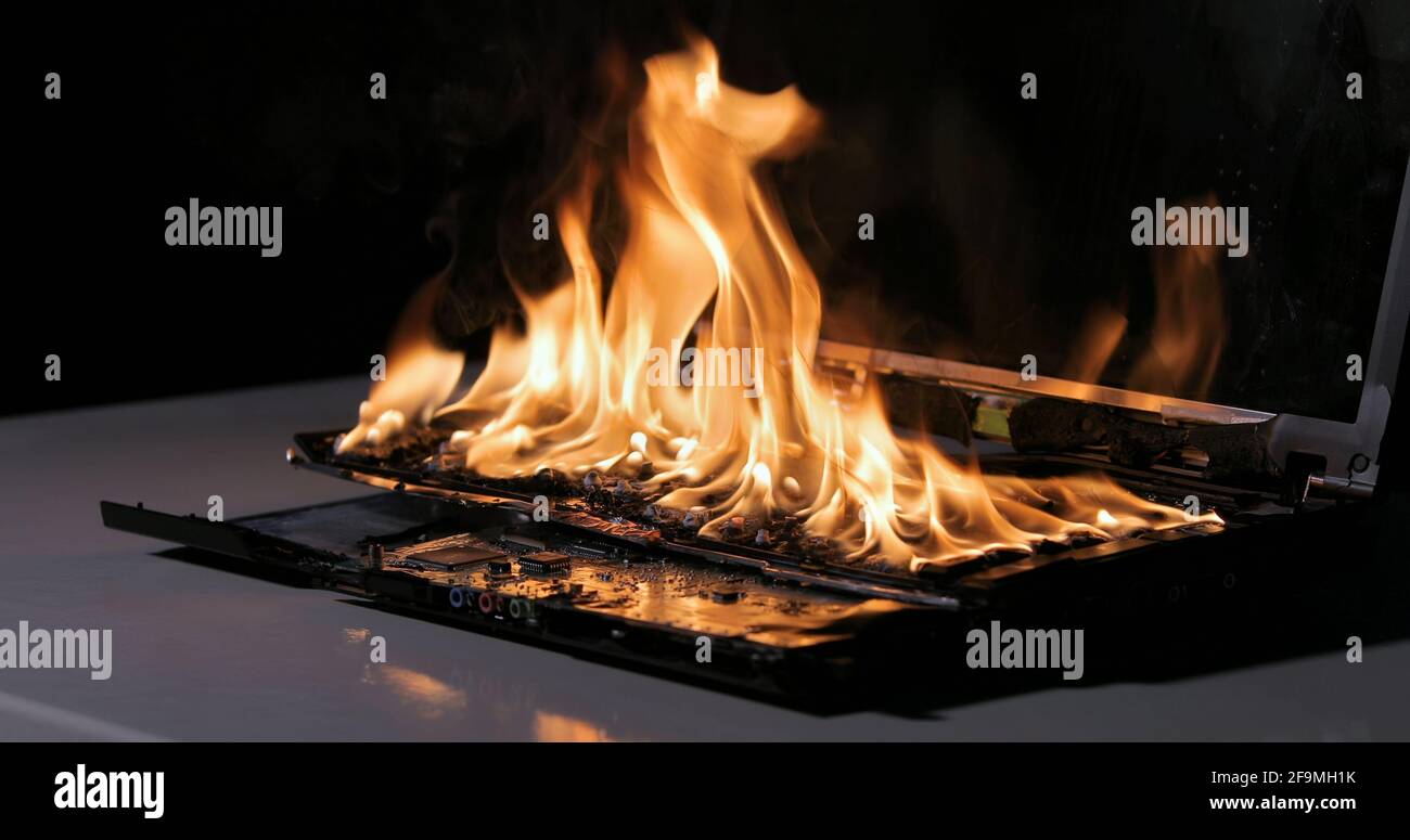 Burning laptop computer electronics closeup Stock Photo - Alamy