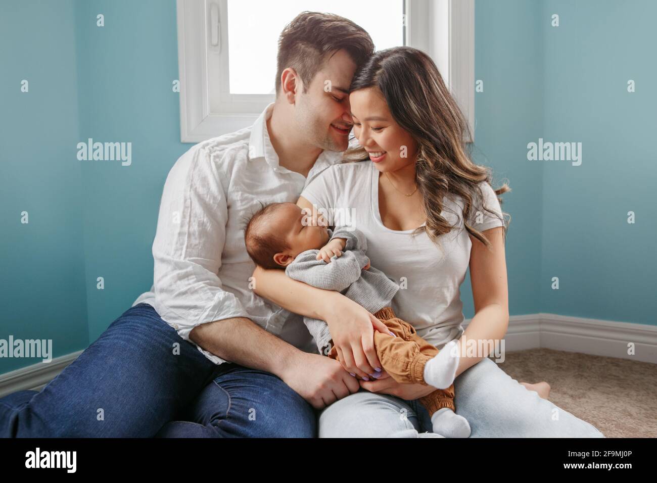 Young family with newborn baby boy at home. Happy parents with kid ...