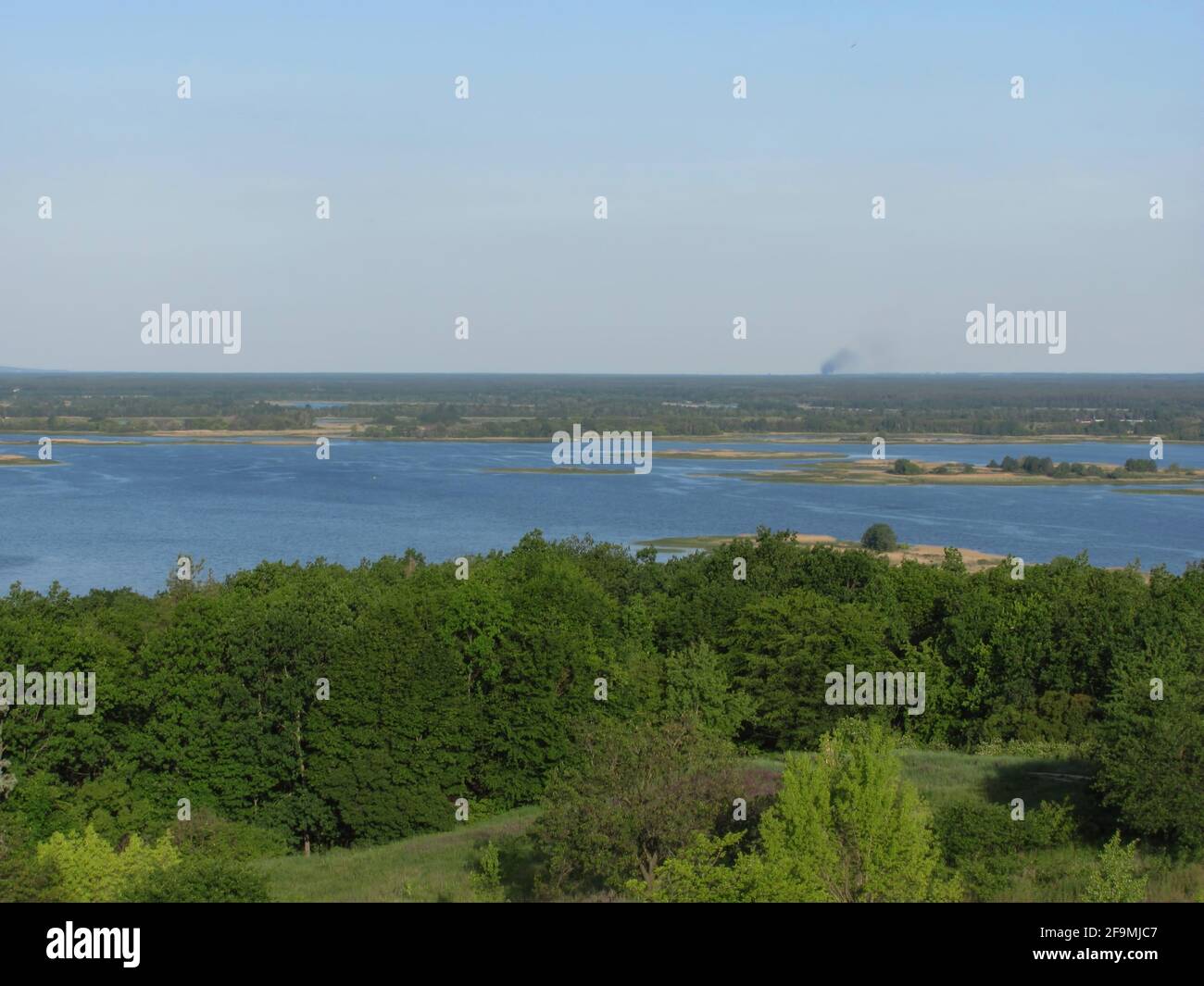 landscape background: green forest, river with islands and blue sky ...