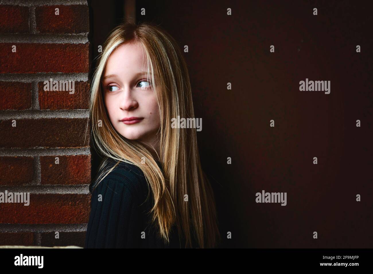 Beautiful tween girl with blond hair looking thoughtful Stock Photo - Alamy
