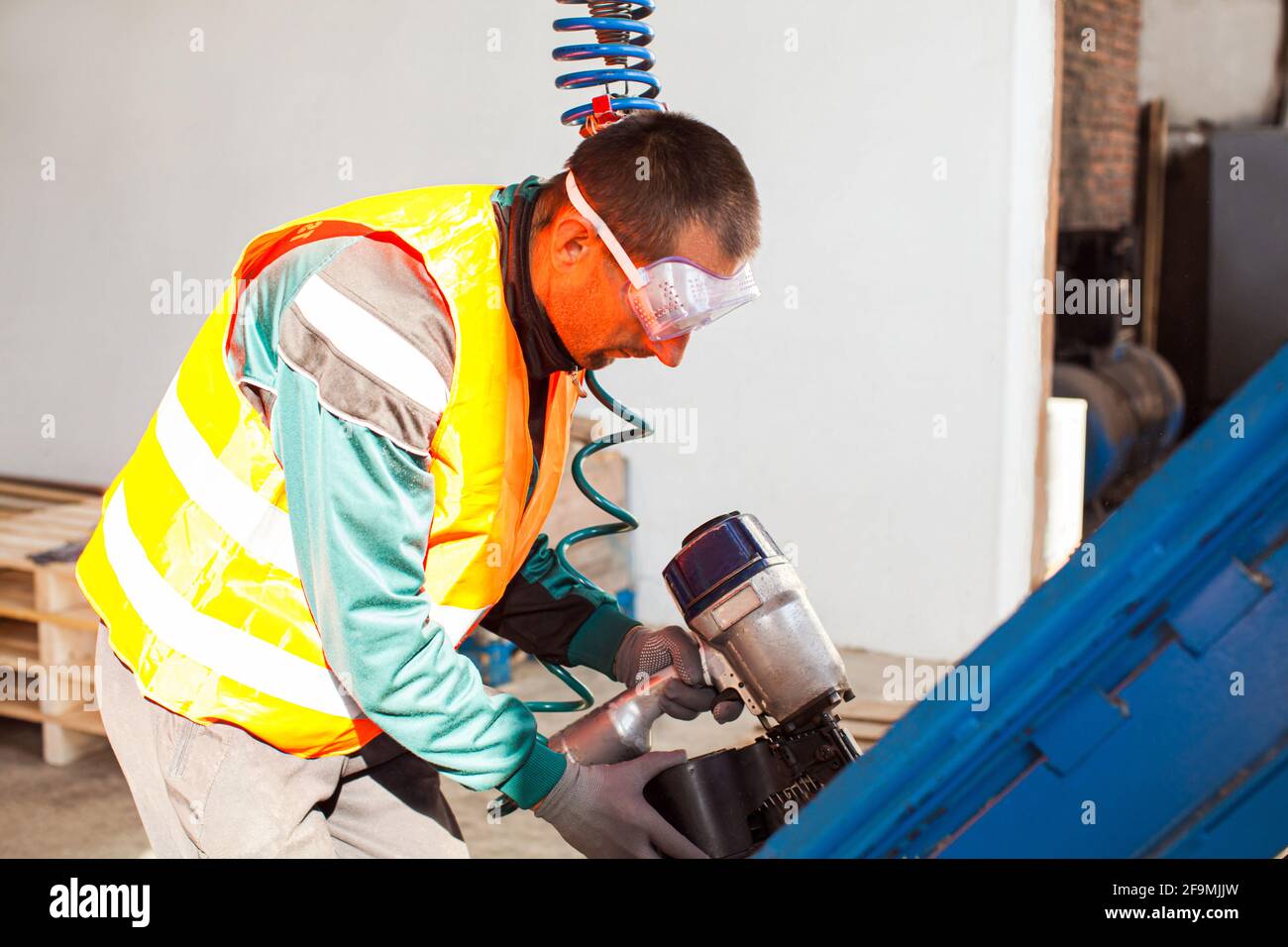 Professional furniture production factrory worker using pneumatic ...