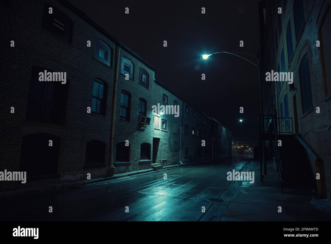 Dark urban city alley at night after a rain featuring vintage ...