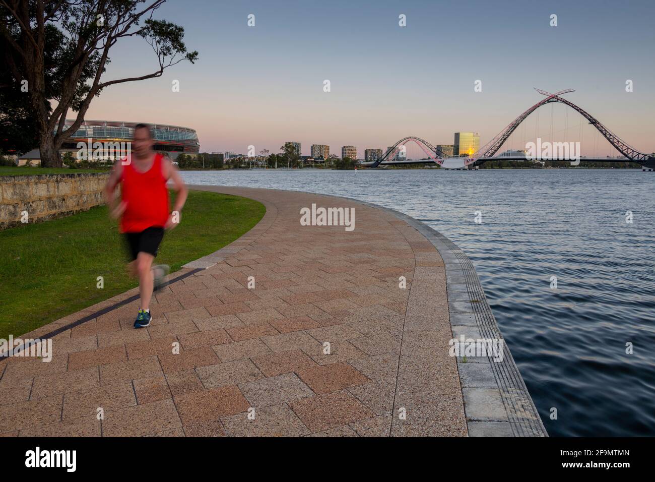 A jogger at Claisebrook Cove, East Perth with the Swan River and ...