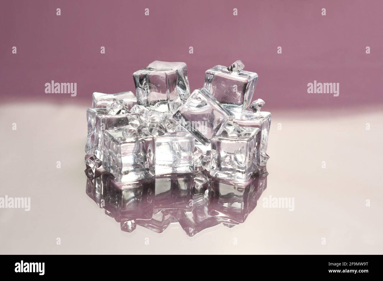 ice stone on reflective surface of background with drops, idea of a ...