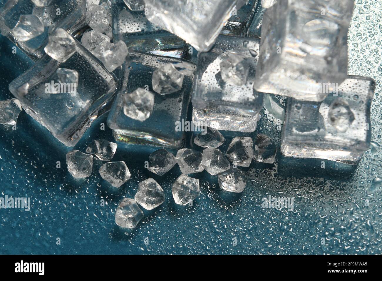 ice stone on reflective surface of background with drops, idea of a ...