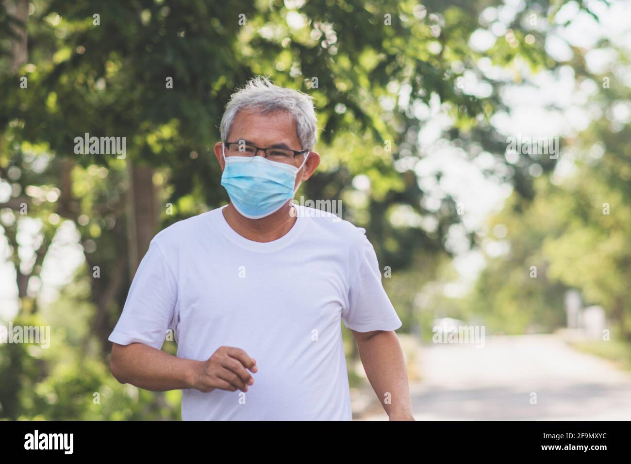 Old man wear face mask running exercise on morning , mask protect ...