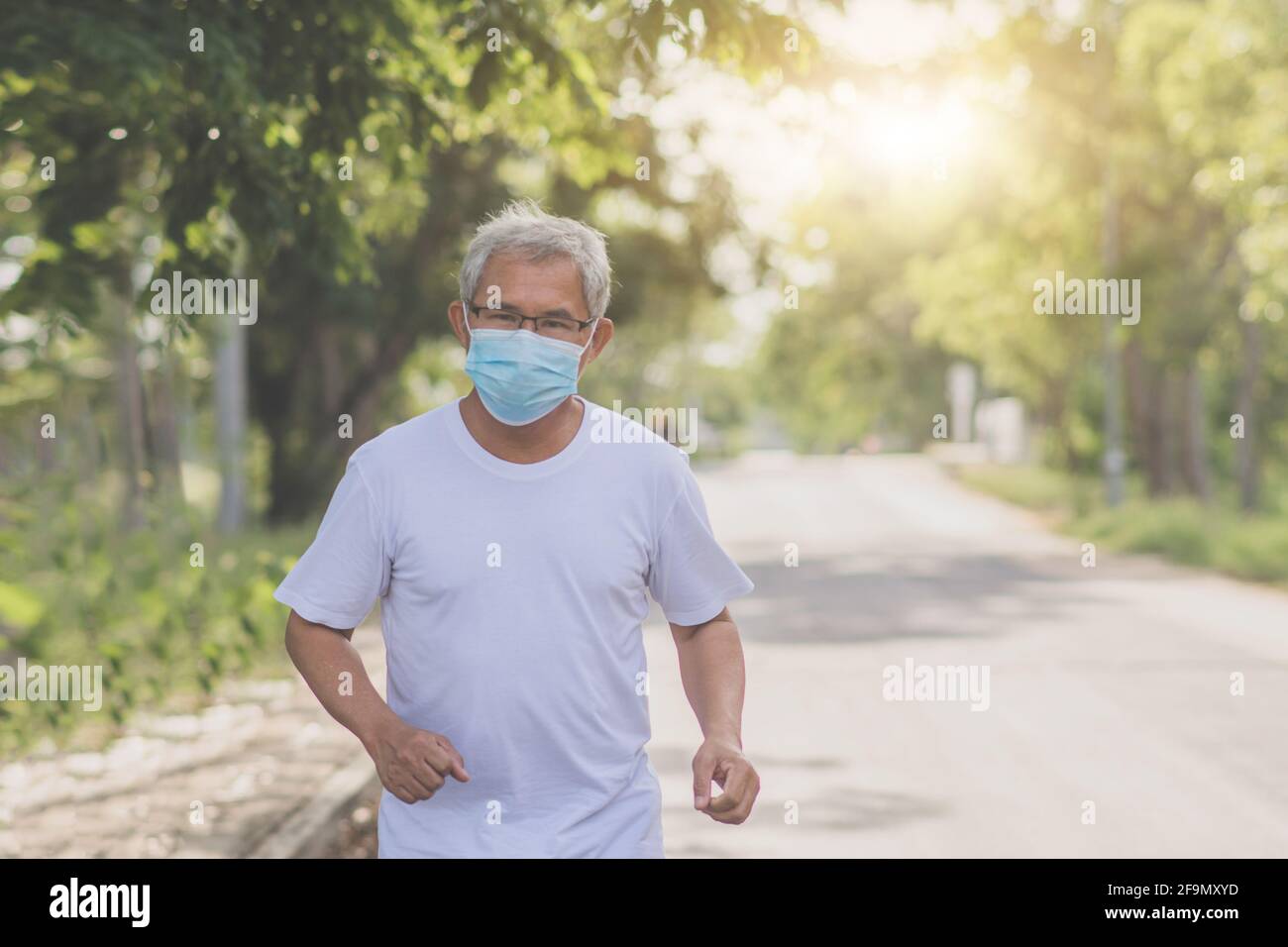 Old man wear face mask running exercise on morning , mask protect ...