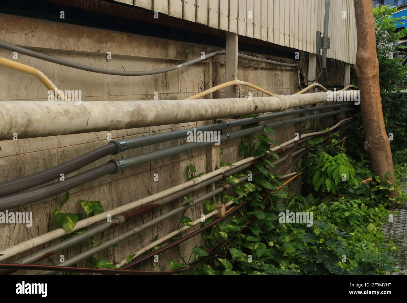 Installation of electrical conduits attached to the wall in the garden ...