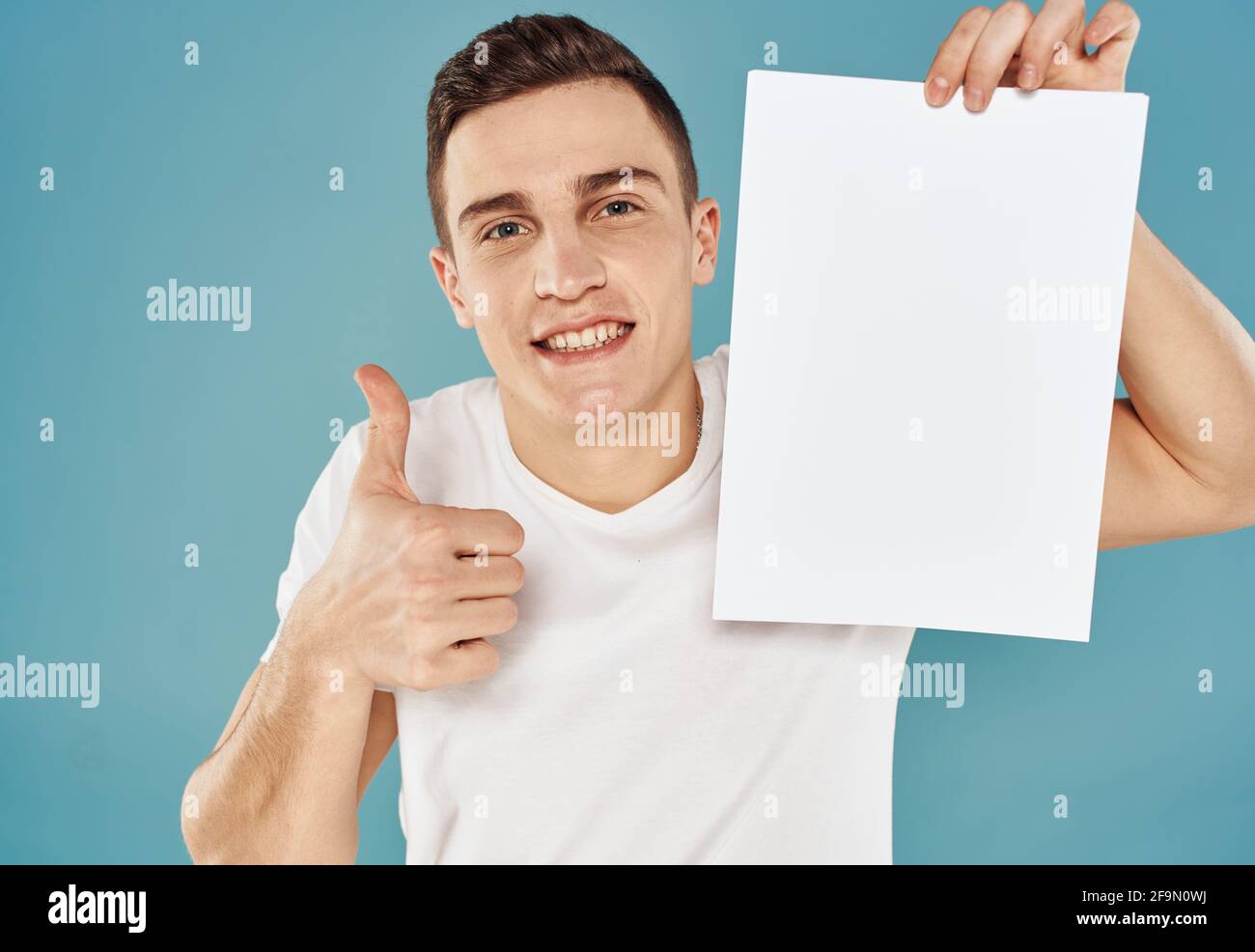 guy with flyer in hand mockup blue background cropped view Stock Photo ...