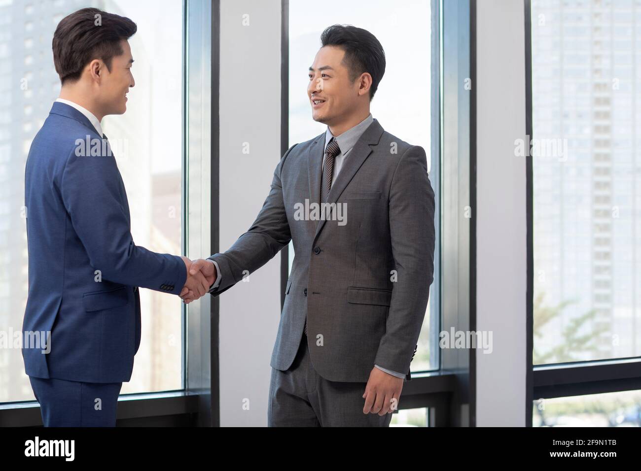 Successful businessmen shaking hands Stock Photo - Alamy