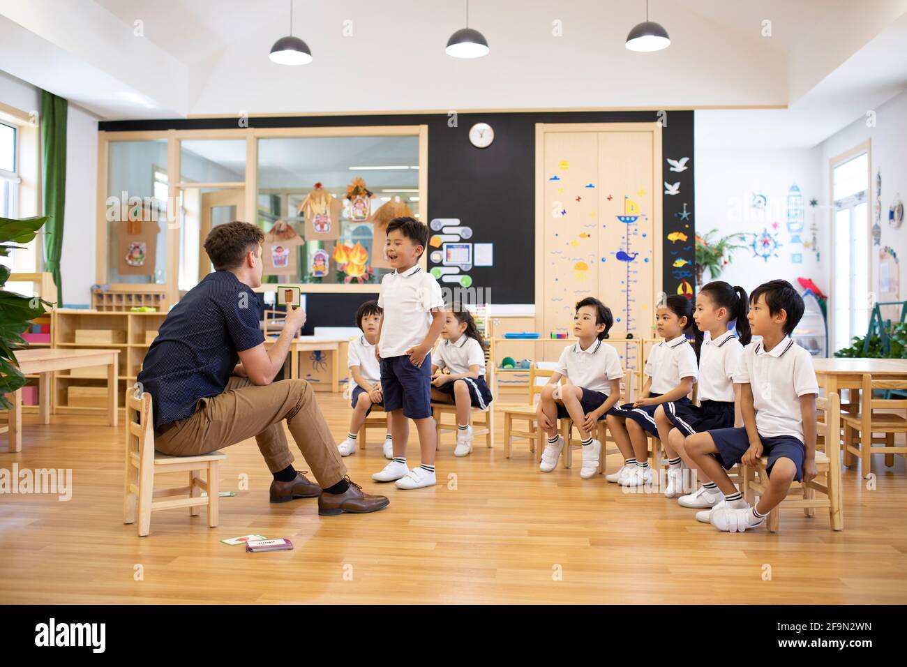 Foreign teacher teaching children English in classroom Stock Photo - Alamy