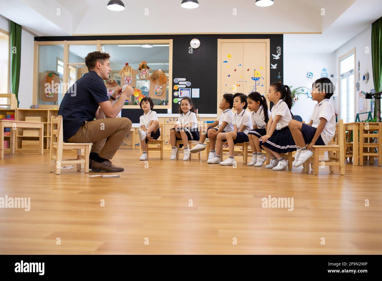 Foreign teacher teaching children English in classroom Stock Photo - Alamy
