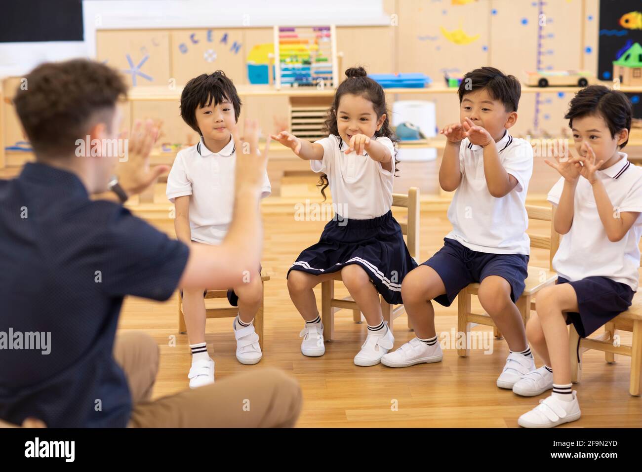 Foreign teacher and children playing games in classroom Stock Photo - Alamy