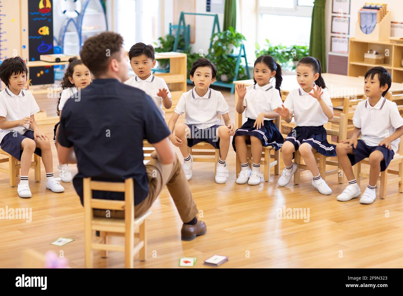 Foreign teacher teaching children English in classroom Stock Photo - Alamy