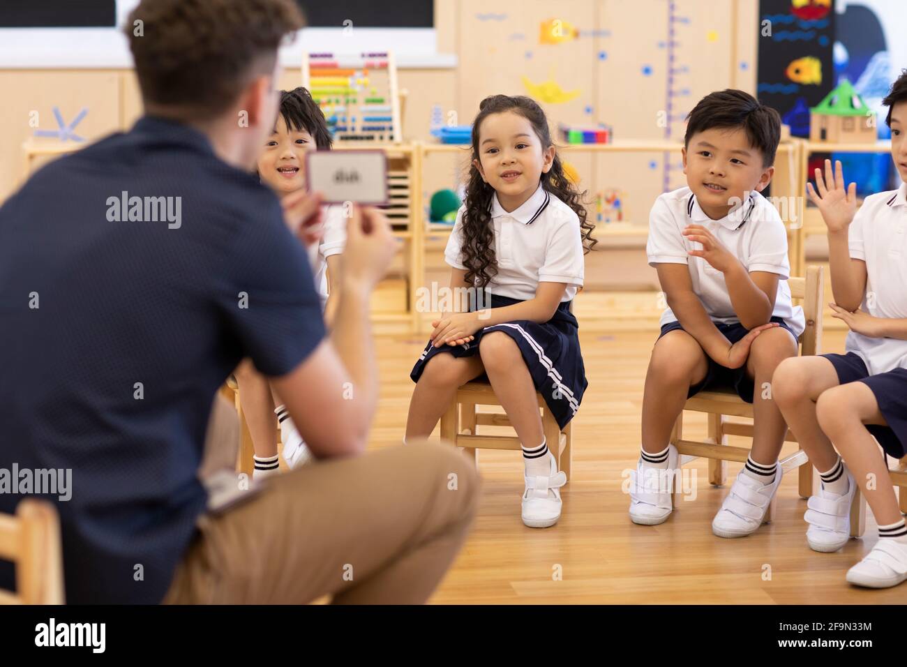 Foreign teacher teaching children English in classroom Stock Photo - Alamy
