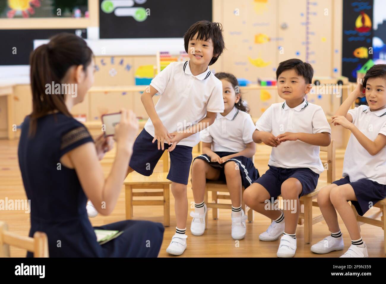 Teacher and children in classroom Stock Photo - Alamy