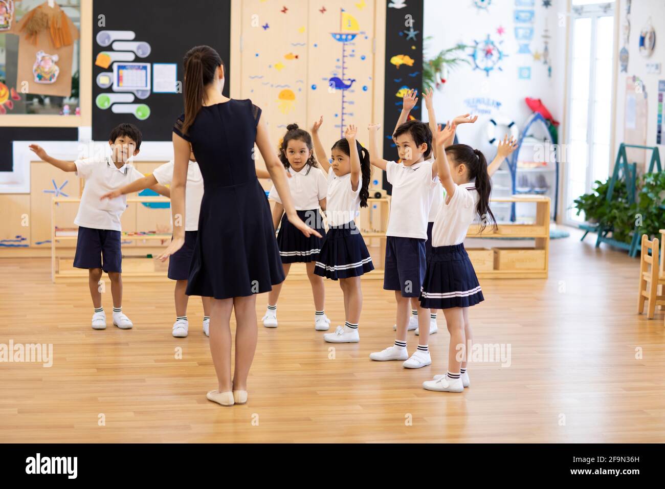Teacher teaching children dancing in classroom Stock Photo - Alamy