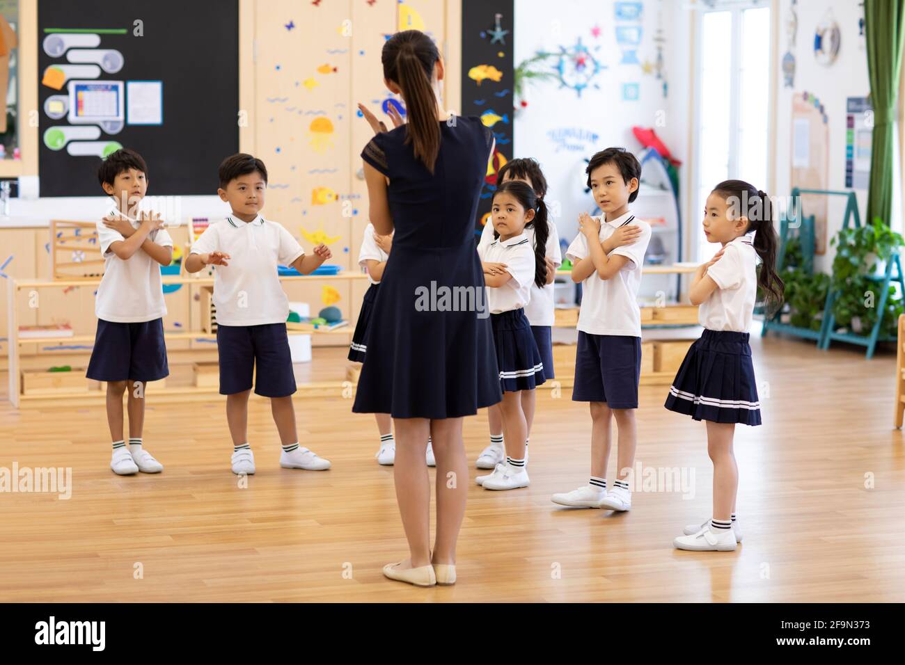 Teacher teaching children dancing in classroom Stock Photo - Alamy