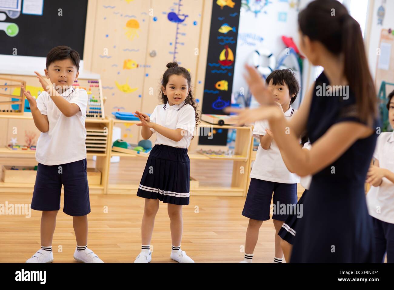 Teacher teaching children dancing in classroom Stock Photo - Alamy