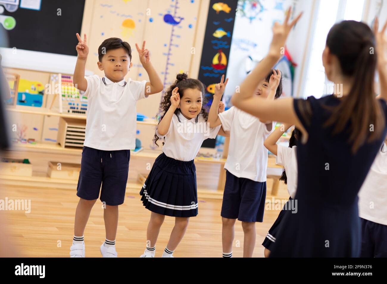 Teacher teaching children dancing in classroom Stock Photo - Alamy