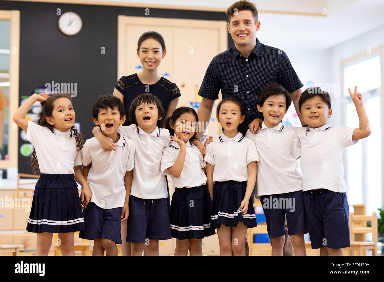Teachers and children in classroom Stock Photo - Alamy