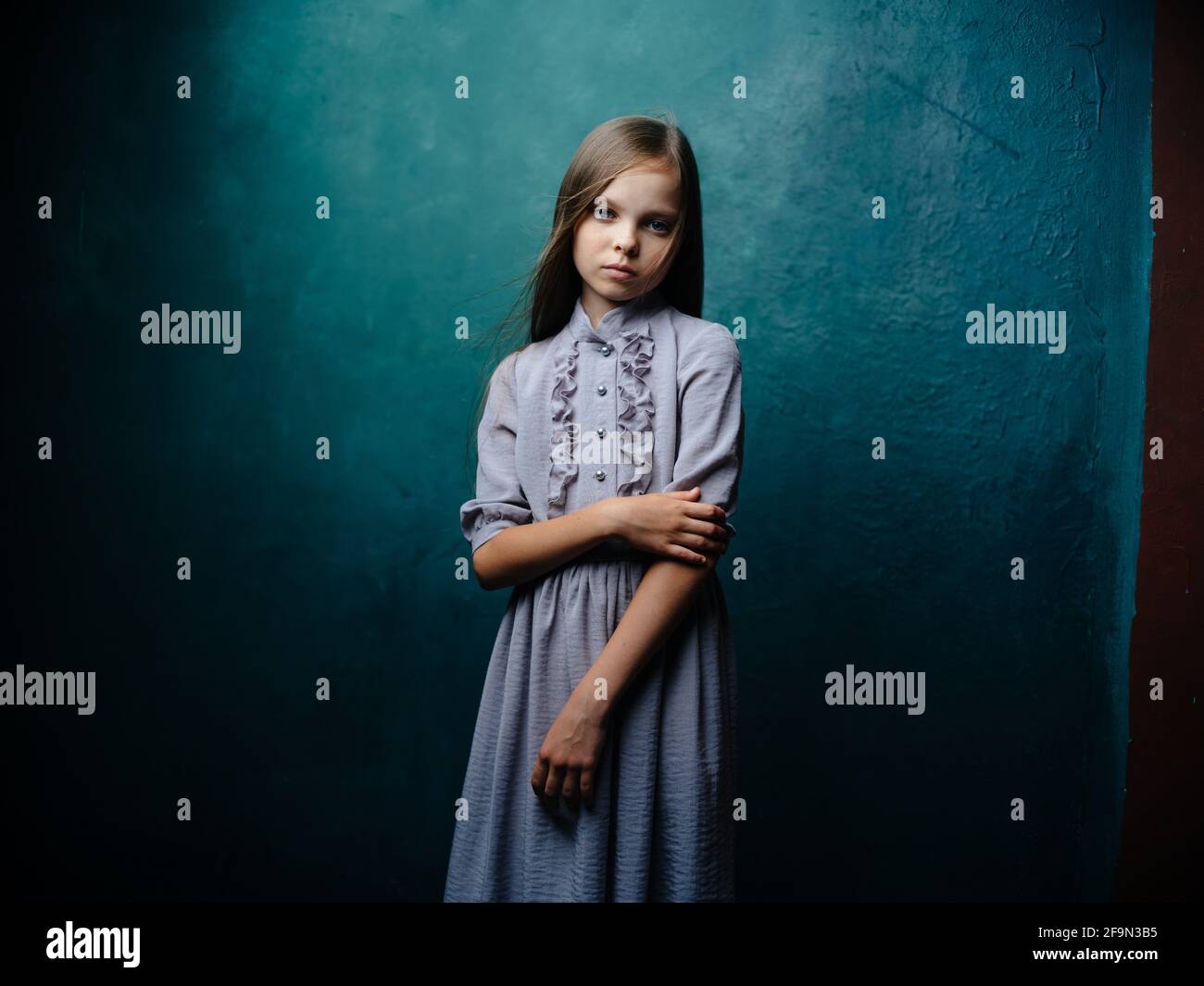 Pretty girl in a gray sundress with loose hair on a turquoise ...